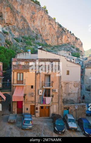 Residences in the old town of Cefalu overlooked by steep rock face of ...