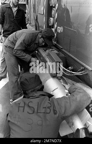 Two crewmen, aboard the frigate USS TRIPPE (FF-1075), load a Mark 46 ...