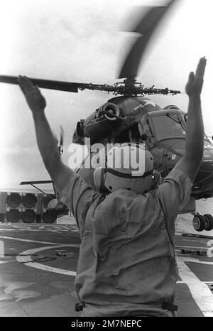 A flight deck crewman signals to an SH-2 Seasprite light airborne multi ...