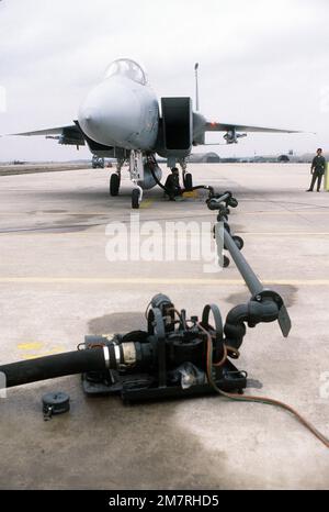 AN F-15 Eagle aircraft is being refueled from a fuel truck. The ...