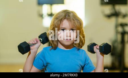 Kid raising a dumbbell. Cute child training with dumbbells. Kids ...