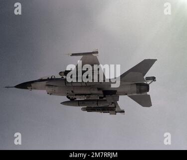 An air-to-air left underside view of an F-16B Fighting Falcon aircraft ...