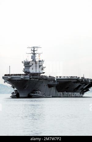 Crewmen line the rails of the nuclear-powered aircraft carrier USS ...
