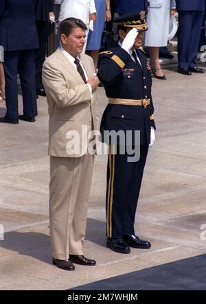 President Ronald Reagan stands as the national anthem is played during ...