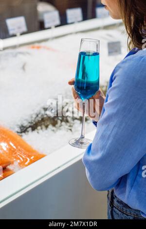 Blue sparking wine drink in glass on the white background with mint and ...