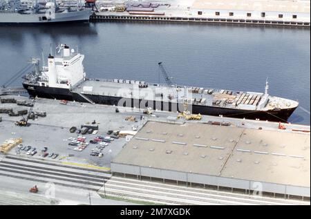 The vehicle cargo ship USNS COMET (T-AKR-7) is docked at a pier ...