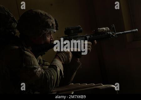 A sniper team member provides security on the entrance to the covered ...