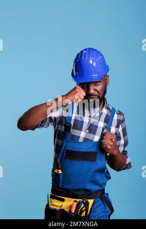 Confident man showing fists against yellow background Stock Photo - Alamy