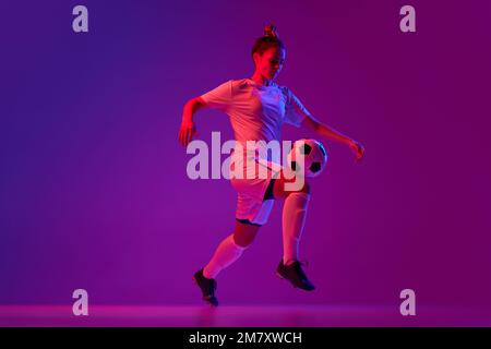 Knee kick. Young professional female football, soccer player in motion ...