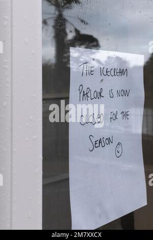 A handwritten closed sign in an Ice cream parlour window in the closed ...