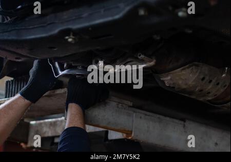 Repair of undercarriage of front suspension of vehicle in garage of car ...