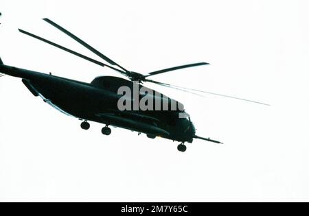 A right side view of an HH-53 Super Jolly helicopter reeling down a ...