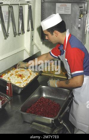A mess management specialist prepares food for a picnic aboard the ...