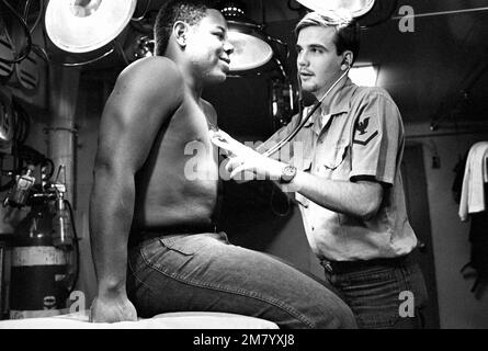 A crewman aboard the tank landing ship USS SUMTER (LST 1181) uses ...