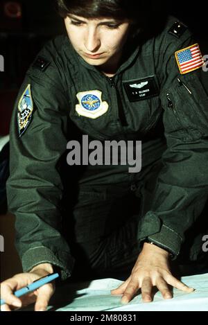 First LT. Terri Ollinger, co-pilot, assembles a map in the passenger ...