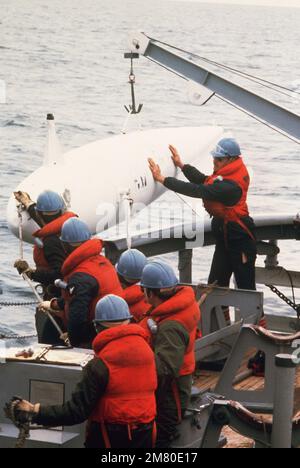 Crewmen hoist a 900-pound buoy, or "pig", aboard the ocean minesweeper ...
