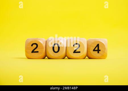 Wooden cubes with numbers 2024 yellow background Stock Photo - Alamy