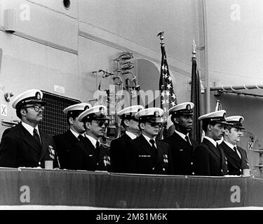 Crew members aboard the frigate USS WHIPPLE (FF-1062) stand at the ship ...