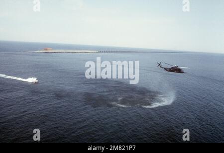 An air-to-air right view of an RH-53D Sea Stallion helicopter towing a ...