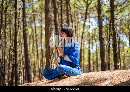 Side view of a woman clasping hands at the beach. Namaste pose Stock ...