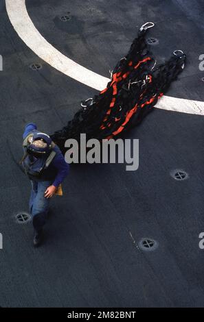 A crewman aboard the tank landing ship USS SUMTER (LST 1181) uses ...