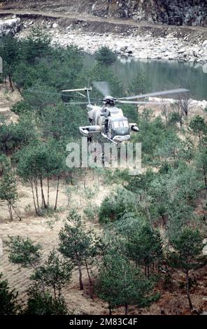 A pararescueman and a "downed" pilot are hoisted aboard an HH-3C ...