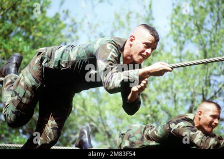 Marine recruits cross a rope on the "slide for life" while running the ...