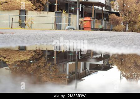 stagnant pool of water scene after rain at the suburb asphalt street ...