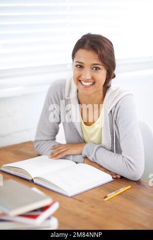 Studying diligently. Portrait of a smiling young university student ...