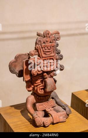 Pre-Hispanic Zapotec ceramic figure of a kneeling man with a mask over ...