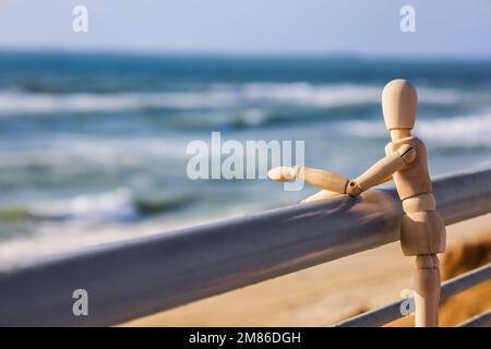 Wooden mannequin on fence near sea, closeup Stock Photo - Alamy