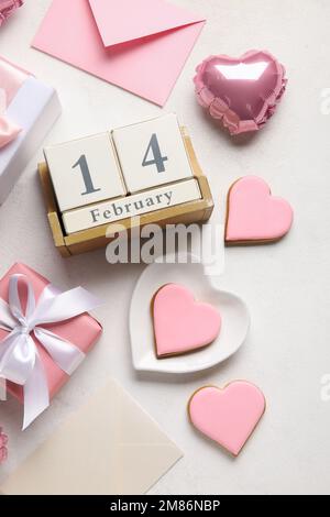 Tasty heart shaped cookies, calendar with date 14 FEBRUARY and gift on ...