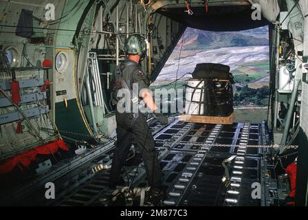 TSGT Gambert of the 345th Tactical Airlift Squadron drops cargo from a ...