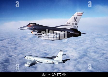 An air-to-air left side view of a 50th Tactical Fighter Wing F-16A ...