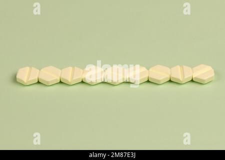 Hexagonal pills on light green background. Extreme closeup. High ...