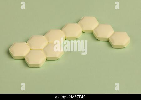 Hexagonal pills on light green background. Extreme closeup. High ...
