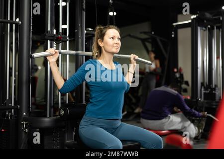 Woman is engaged in a simulator for development of back muscles Stock ...