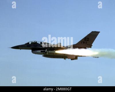 An air-to-air left side view of an F-16B Fighting Falcon aircraft with ...