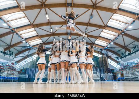 A group of cheerleaders are captured in a dynamic and athletic moment ...