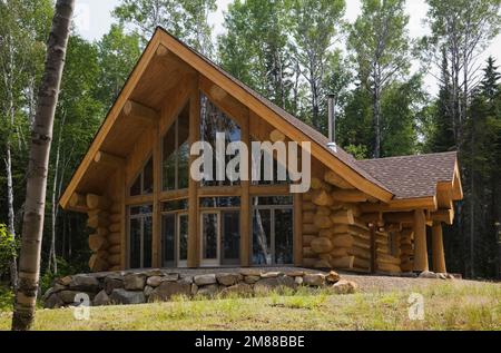 Side view of handcrafted Eastern white pine cottage style log home in ...