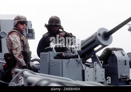 A GUNNERY Division 4 gunner's mate mans a 25mm Mark 38, Mod 0 gun ...