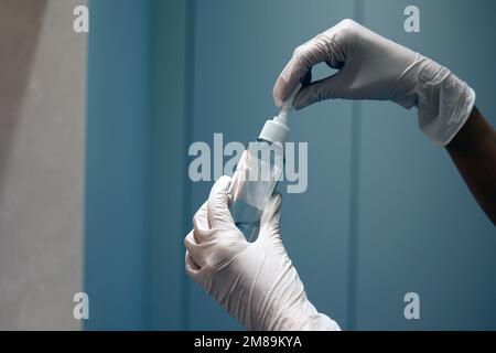 Gloved hands holding the liquid bottle in the laboratory Stock Photo ...