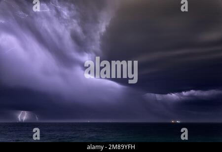 Thundercloud with lightning at night over the ocean Stock Photo - Alamy