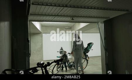 Mother opening storage room in underground parking space. Person opens ...