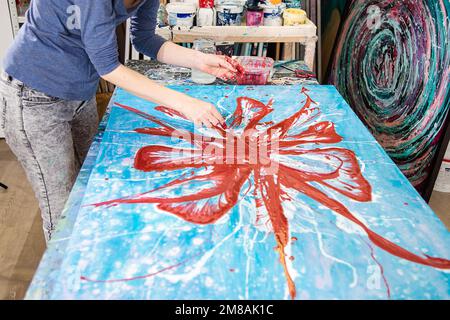 Cropped photo of hands of woman artist stained with red paint painting ...