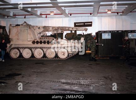 An M-578 light armored recovery vehicle is driven off a railroad ...