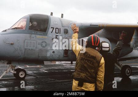 A flight deck officer and a catapult crewman stand by as an F-14A ...