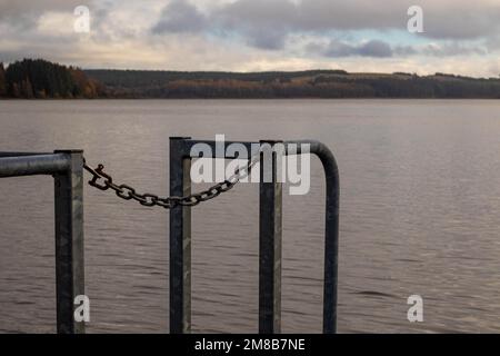chain on jetty by lake cloudy day background Stock Photo - Alamy