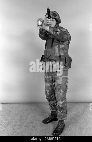 Tactical pistol with a flashlight and a shooting target with bullet ...