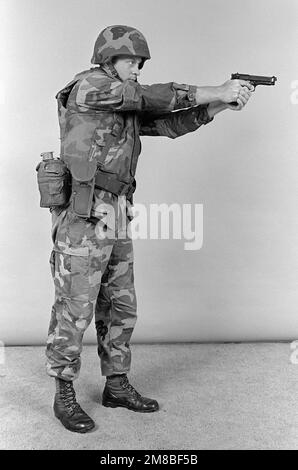 A Marine demonstrates a standing firing position with an M-870, Mark 1 ...